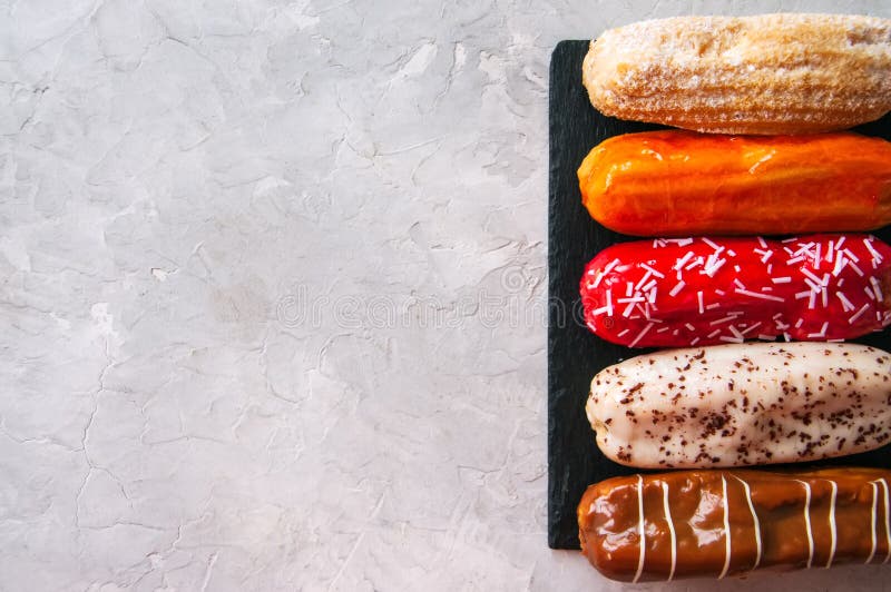 L'ensemble D'eclairs Assortis a Servi Sur Un Panneau D'ardoise Sur Une ...