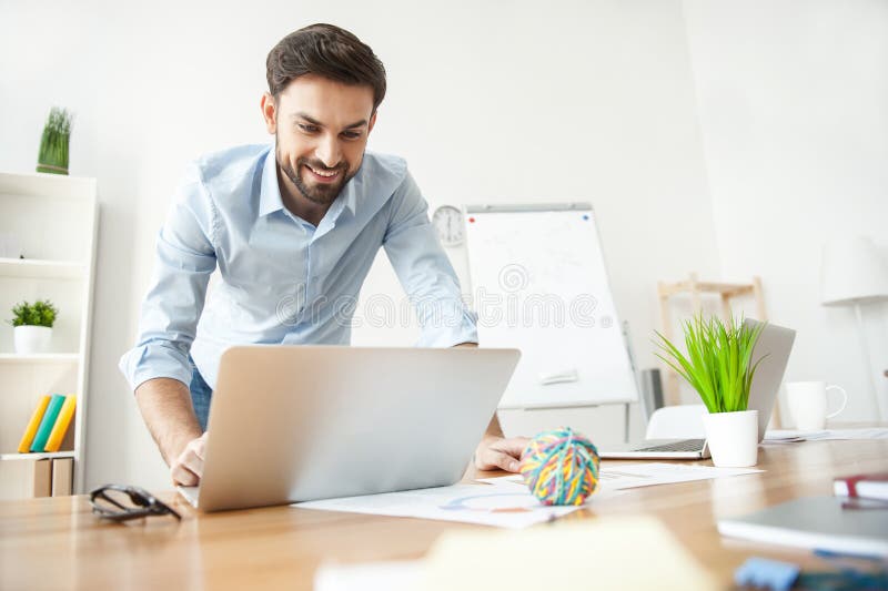 L'uomo D'affari Attraente Sta Lavorando Al Computer Immagine Stock ...