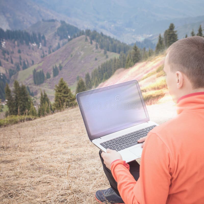 L'uomo Utilizza a Distanza Il Computer Portatile Alla Montagna ...