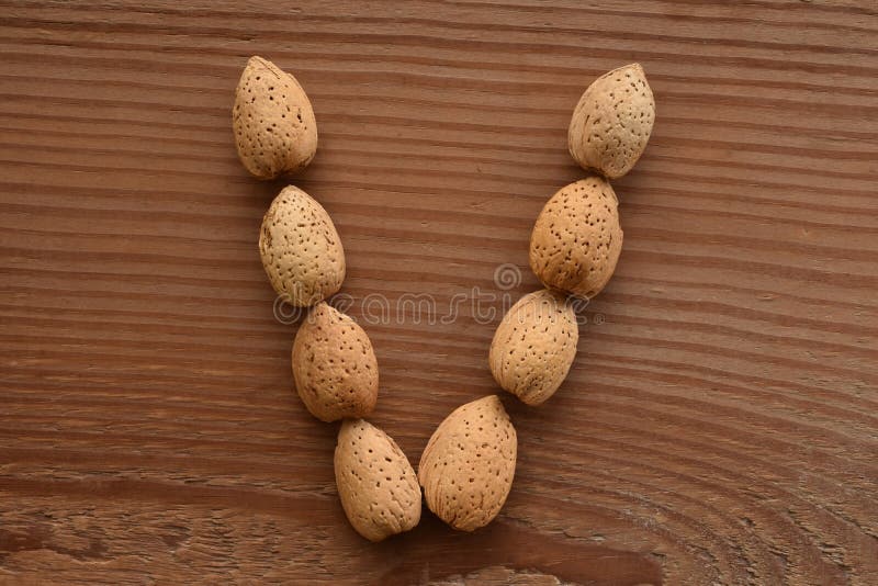 La Letra De Forma De V Con Las Almendras En La Madera Imagen de archivo ...