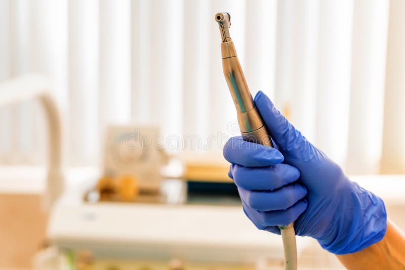 La Main Du Dentiste Dans Le Gant Tient La Machine Dentaire De Perceuse ...