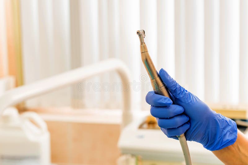 La Main Du Dentiste Dans Le Gant Tient La Machine Dentaire De Perceuse ...