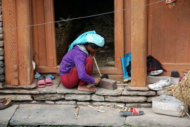 La Mujer Nepalesa Garabatea Una Vara En El Umbral De La Casa, Para ... La Mujer Nepalesa Garabatea Una Vara En El Umbral De La Casa, Para ...