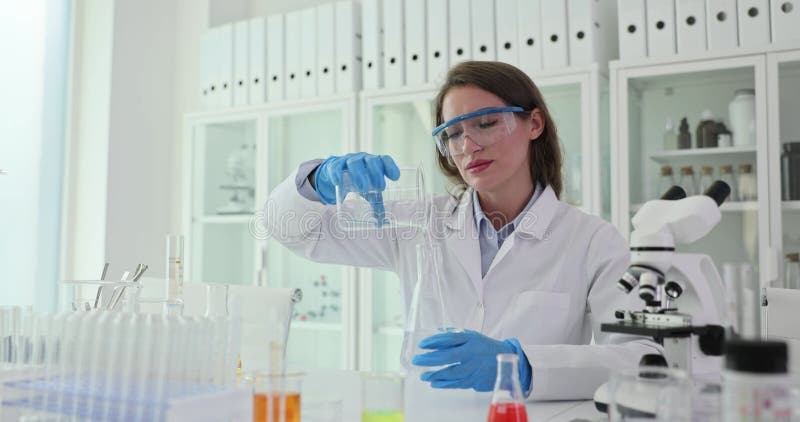 Lab Assistant Pours Liquid from Beaker To Flask at Table Stock Footage ...