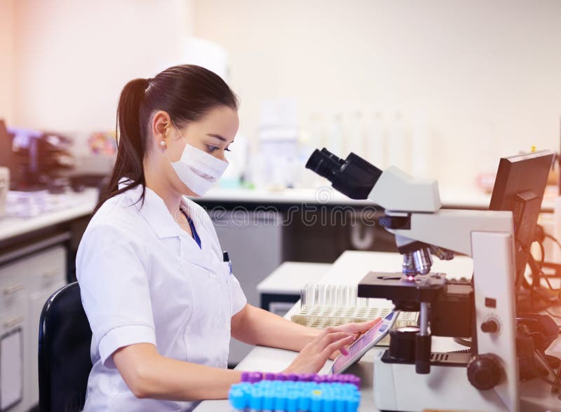 The Lab Expert at Work. a Young Scientist Using a Digital Tablet while ...