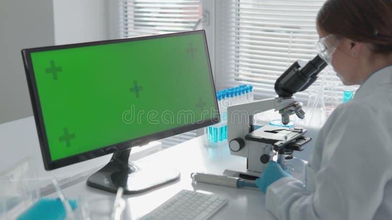 A Laboratory Researcher is Actively Using a Microscope while ...