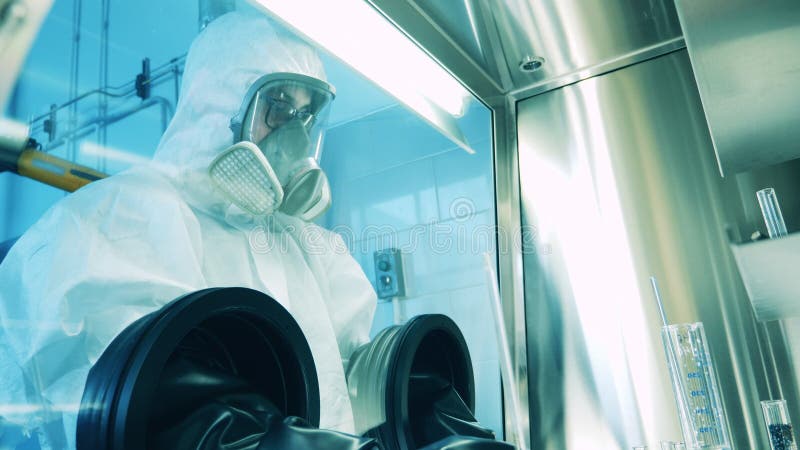 Lab Worker in a Hazmat Suit is Analyzing Probes in a Laboratory Cabinet ...