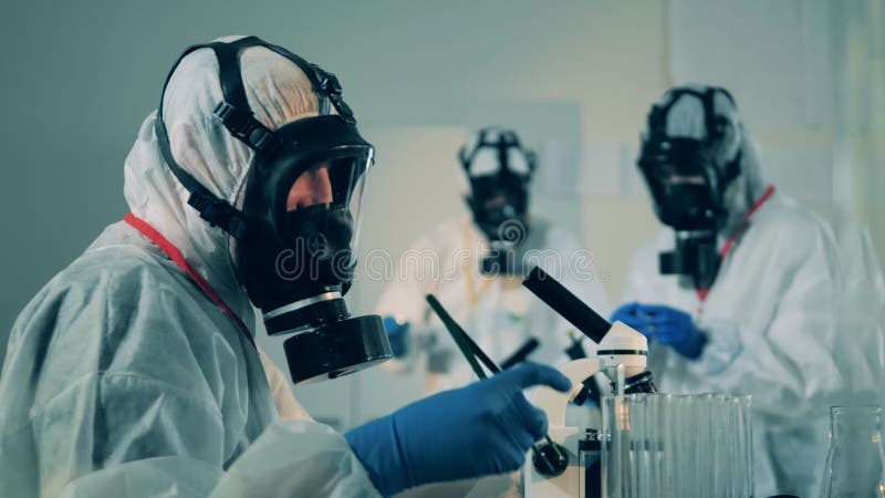 Lab Worker in a Hazmat Suit is Using a Microscope during COVID-19 ...