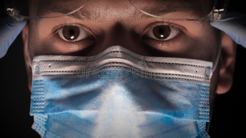 A Lab Worker in a Mask Puts on Protective Work Glasses for Working in ...
