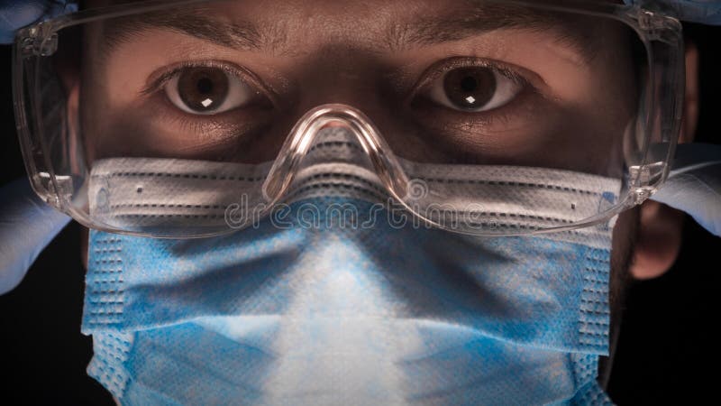 A Lab Worker in a Mask Puts on Protective Work Glasses for Working in ...