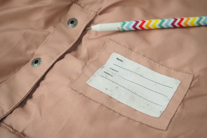 A Label on Soft Pink Fabric Displays Spaces for Name and Comments Stock ...