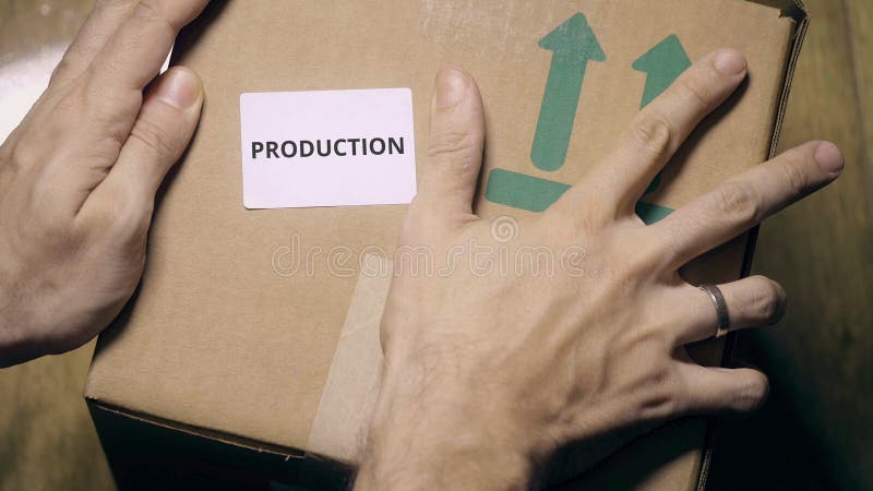 PRODUCTION Sticker on a Carton Stock Photo - Image of employment, hands ...
