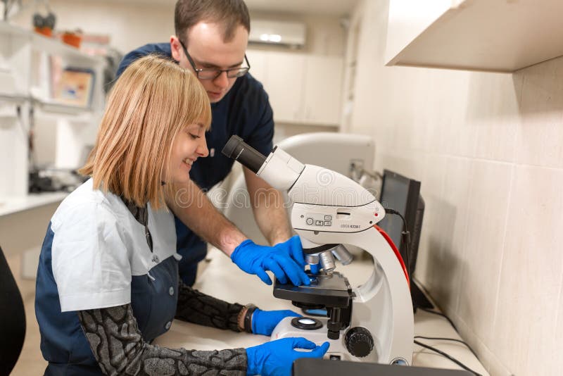 Two Laboratory Assistants. the Guy is Holding a Flask with a Green ...