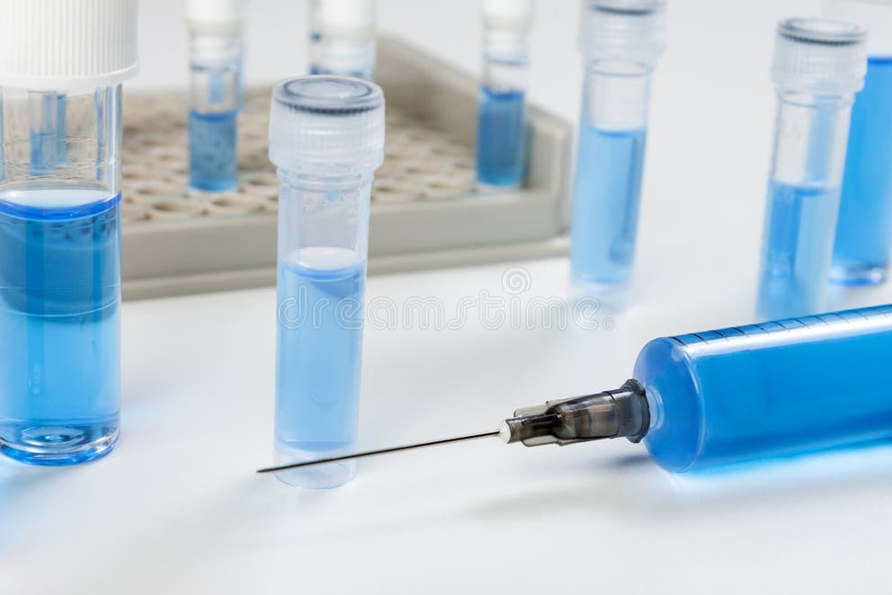 Laboratory Bench with Vials of Blue Fluid and a Syringe Stock Image ...