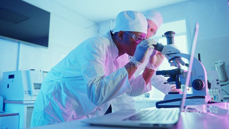 Laboratory Chemists Analyzing Innovative Technology Under Neon Lighting ...