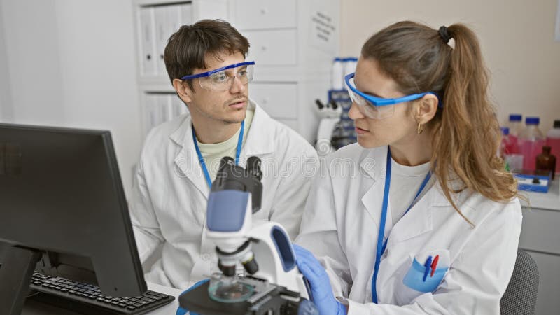 In a Laboratory, a Man and Woman in Lab Coats and Safety Glasses ...