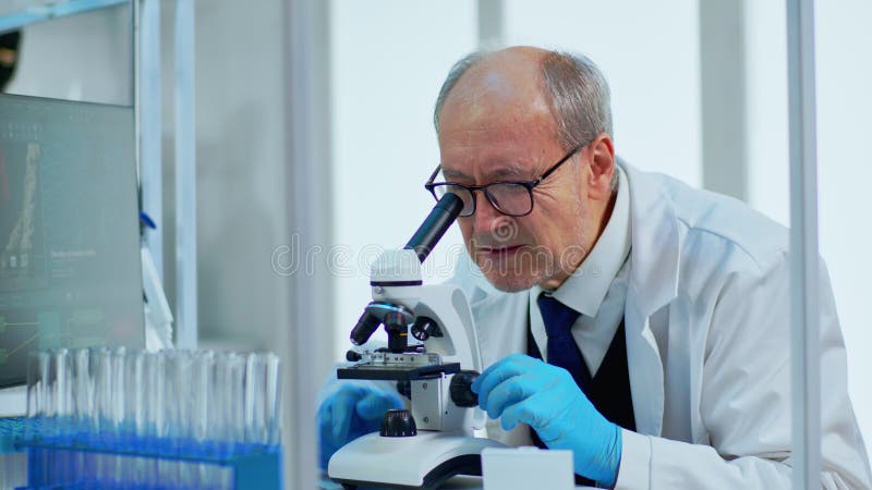 Laboratory Scientist Conducting Experiment Looking at Microscope in ...