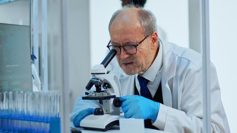 Laboratory Scientist Conducting Experiment Looking at Microscope in ...