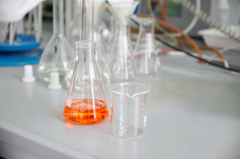 Laboratory Experiment Showing Orange Liquid in a Flask beside a Clear ...