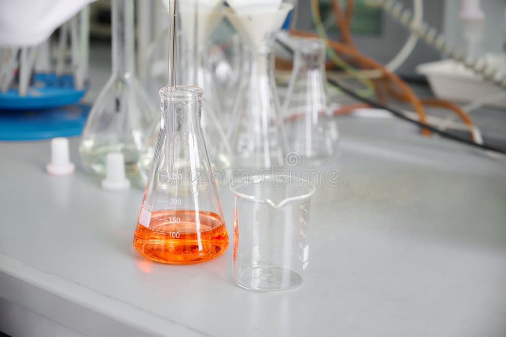 Laboratory Experiment Showing Orange Liquid in a Flask beside a Clear ...