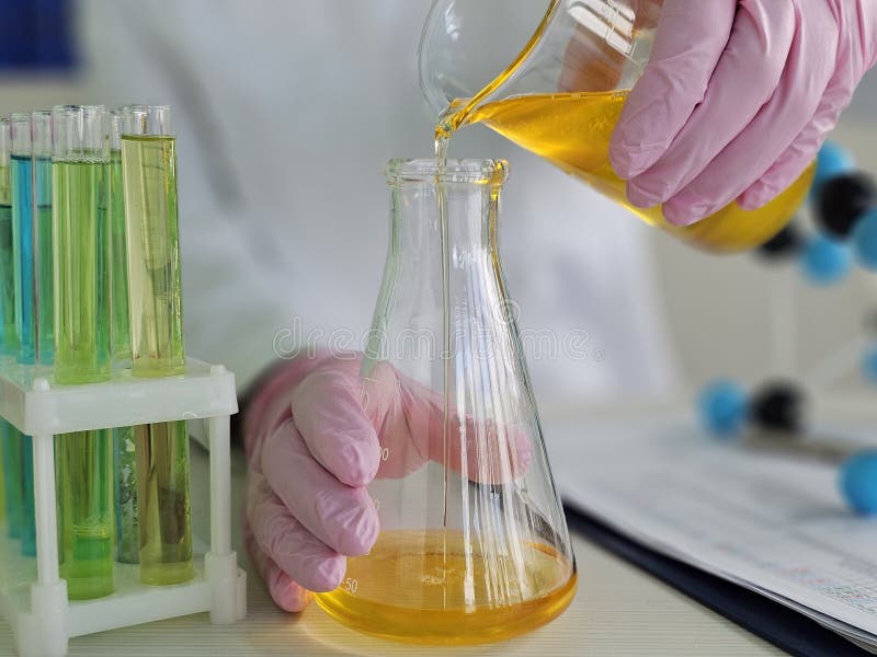 Laboratory Technician Conducts Chemical Experiment Pouring Liquid into Flask during Research ...