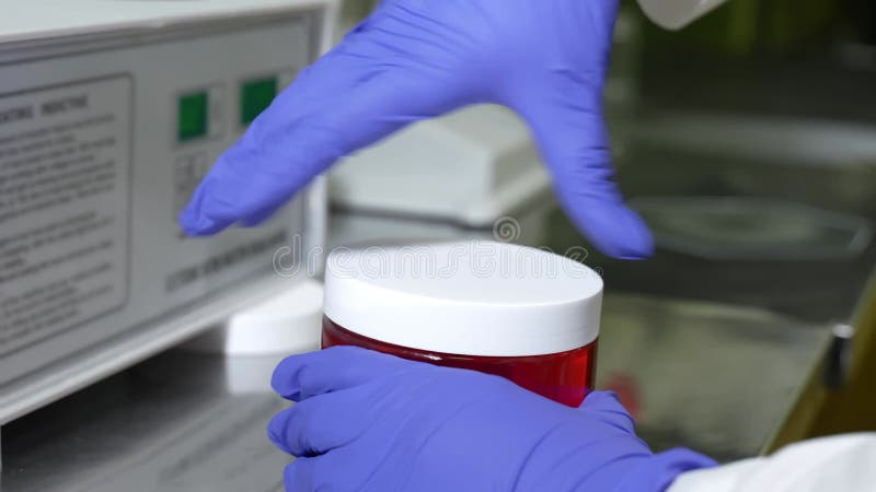 Laboratory Technician Handling a Sample Jar in a Controlled Environment ...