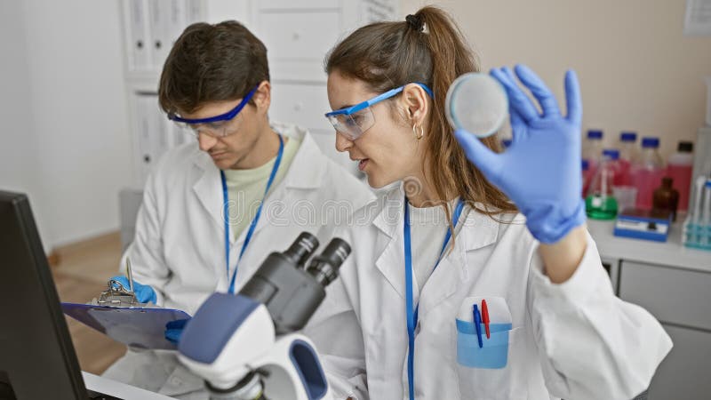 In a Laboratory, a Woman and Man in Safety Glasses Analyze Samples ...