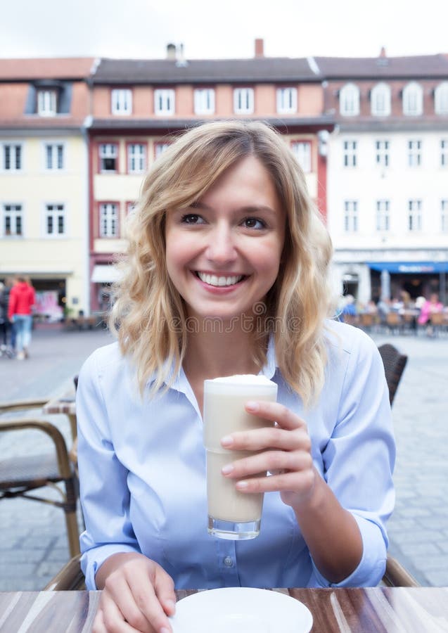Lachende Frau Mit Dem Gelockten Blonden Haar Mit Kaffee Latte Macchiato ... Lachende Frau Mit Dem Gelockten Blonden Haar Mit Kaffee Latte Macchiato ...