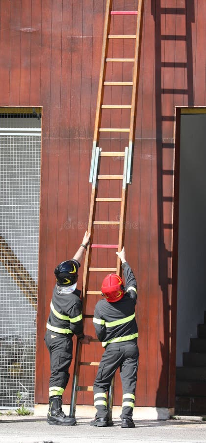 Ladder and Two Firefighter with Helmet in the Fire Station Stock Photo ...