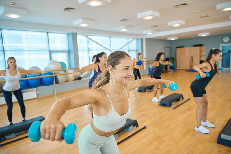 Ladies in Good Mood Exercise with Dumbbells in Training Room Stock ...