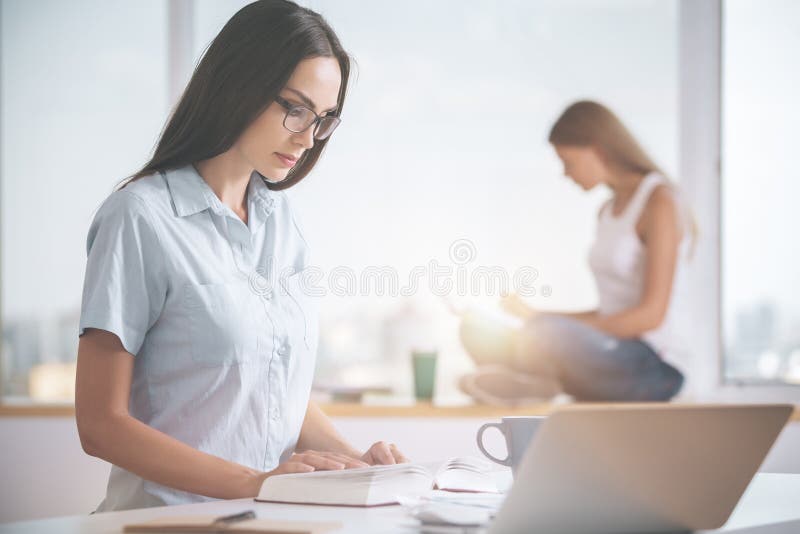 Females reading in office stock image. Image of desk - 77879425