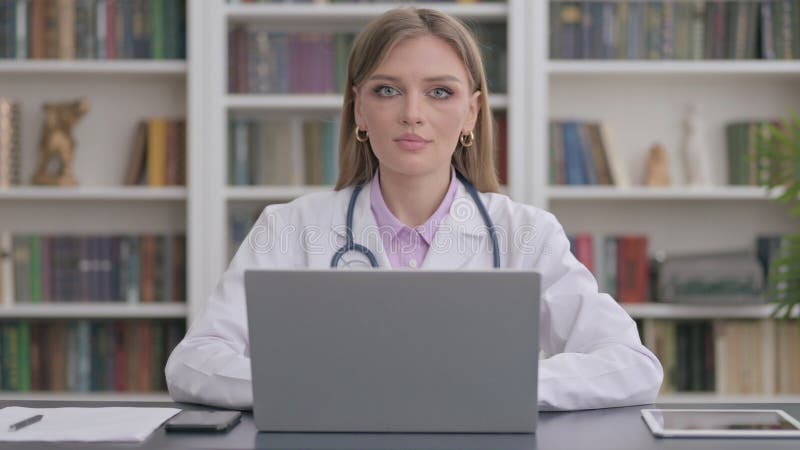 Lady Doctor Looking at Camera while Using Laptop in Clinic Stock Photo ...