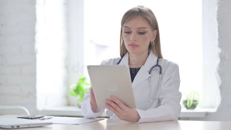 Lady Doctor Using Tablet while Sitting in Clinic Stock Photo - Image of ...
