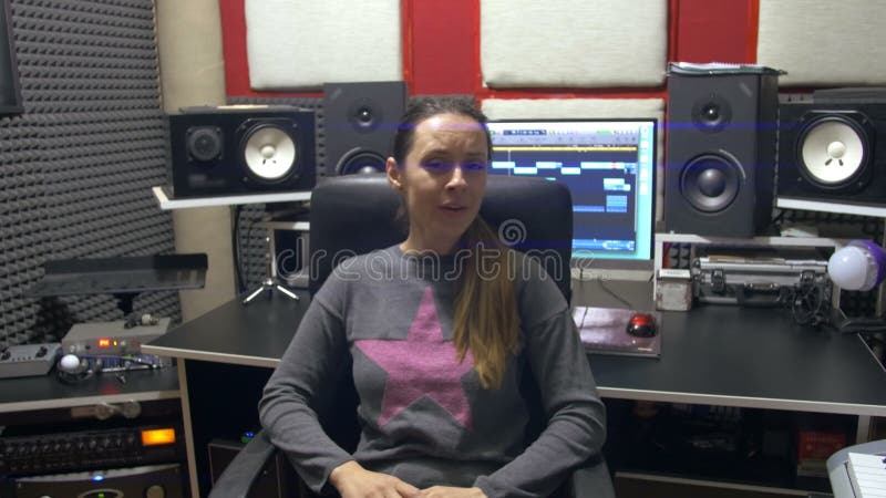 Lady Sitting on a Chair in a Producing Studio and Singing a Song from ...