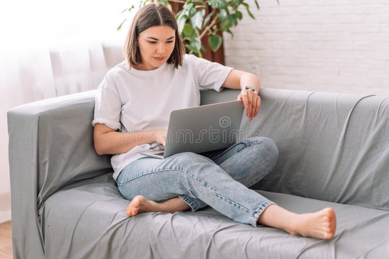 Lady Sitting on the Couch Working on a Laptop Stock Photo - Image of ...