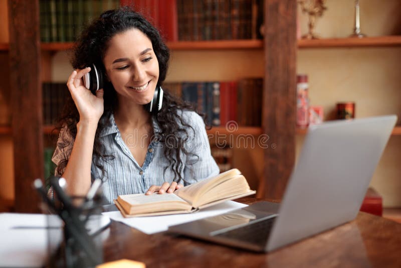Lady Sitting at Desk, Touching Headset, Using Computer, Reading Book ...