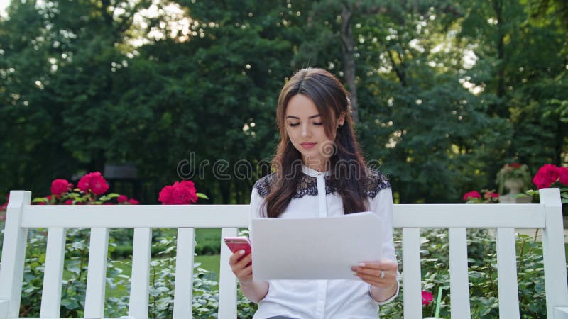 Lady Sitting in the Park, Using a Phone. Data Entry Stock Photo - Image ...