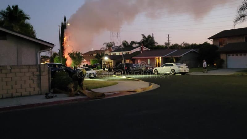 A LAFD Firefighter Attaches a Hose To a Hydrant with a Fire Burning in ...