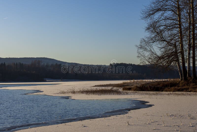 Lake with Autumn Ice at the Shore and with Mountains and a Blue Sky in ...