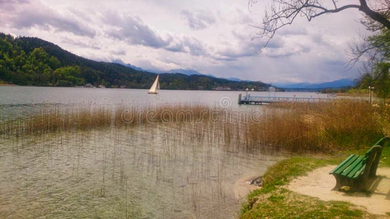 A Lake with a Bench and a Sailing Boat in the Middle Stock Photo ...