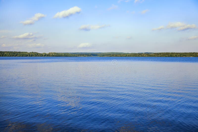 Lake of Bright Blue Color, Sky and Forest on the Coastline Stock Photo ...