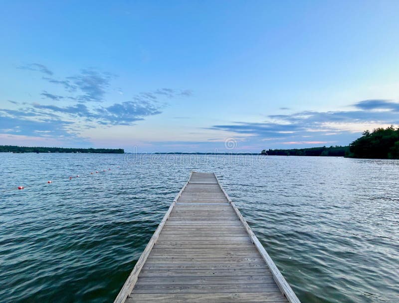 Lake Dock Stretches Out at Sunset with Trees Stock Image - Image of ...