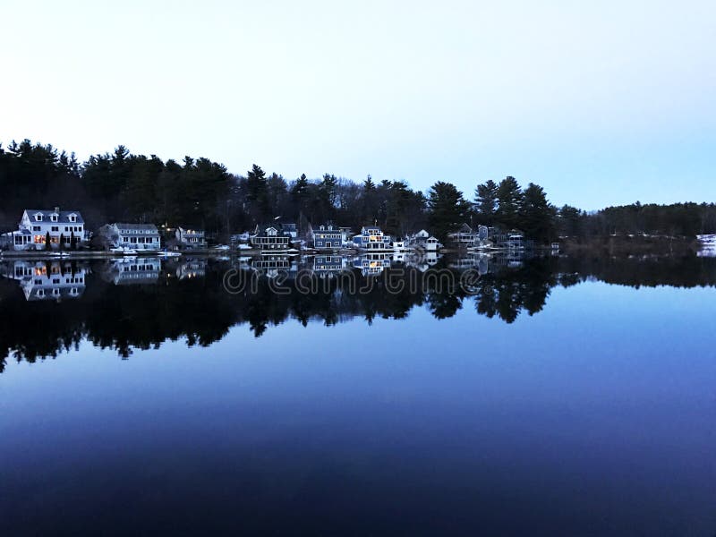 Lake Houses on a Still Blue Lake Stock Photo - Image of dusk, pond ...