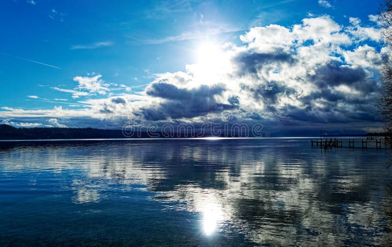 Lake with Reflecting Water Surface and Clouds Stock Photo - Image of ...
