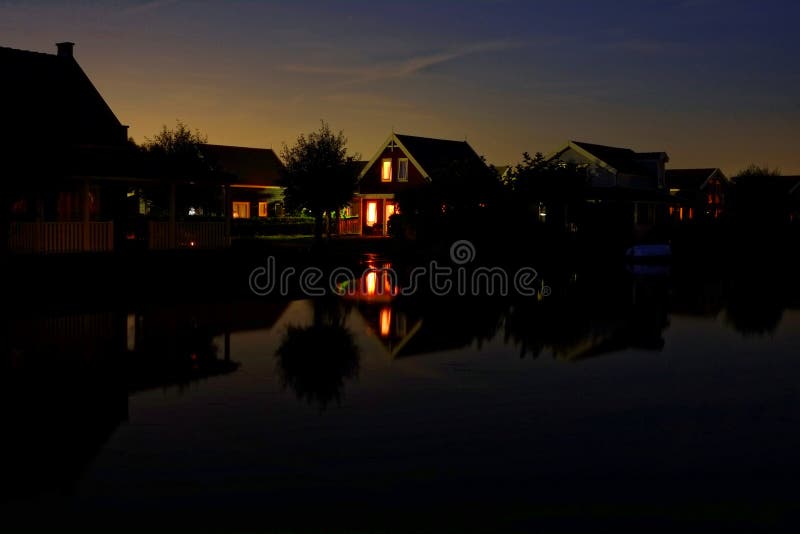 Dutch Lake Resort Scene at Dusk with Lights on in Cozy Homes Editorial ...