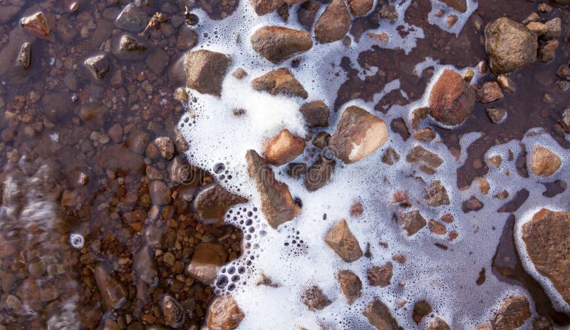 Lake shore foam and rocks stock photo. Image of bubbles - 28054782