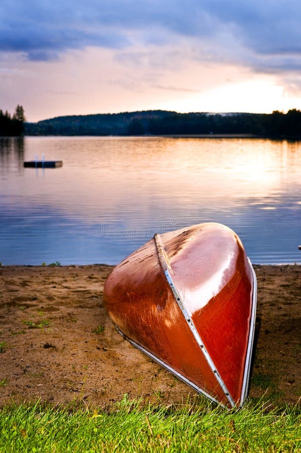 Lake Sunset with Canoe on Beach Stock Photo - Image of peaceful, beach ...