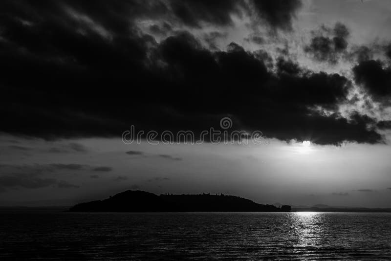 Lake at Sunset with Sun Coming Down from Clouds and Reflecting on Water ...