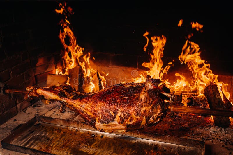 The Lamb is Cooked Entirely on a Spit on the Fire. Cooking Stock Image ...