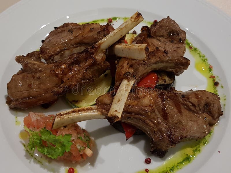 Lamb Meat on the Ribs Cooked Over a Fire and Served in a White Plate ...